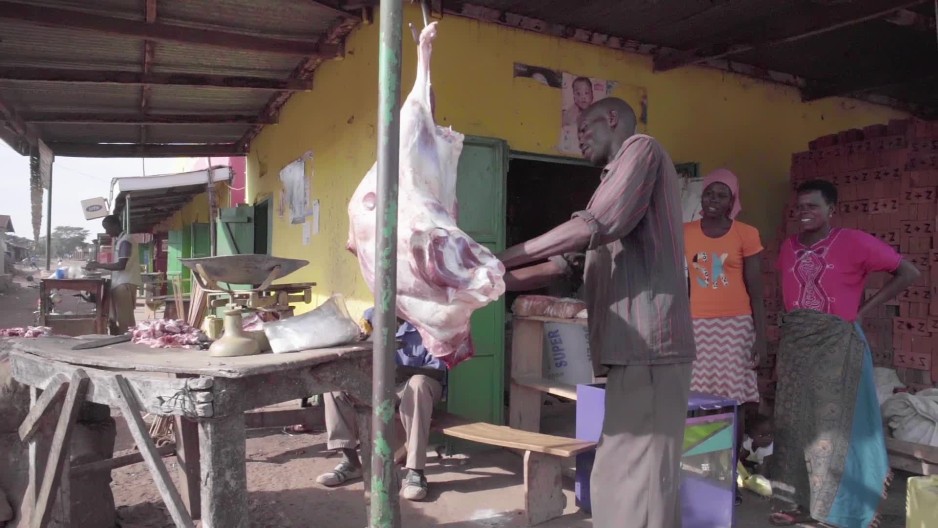 African butcher hacking away at meat suspended from ceiling - Slow ...