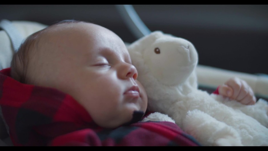 sleeping newborn baby boy hugging stuffed animal toy while takes a nap ...