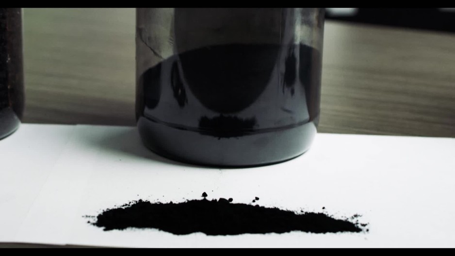 Extreme close up and tilt down of container filled with fine black ...