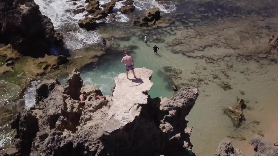 Flyover of people jumping into rock pool at Bridgewater Bay on ...