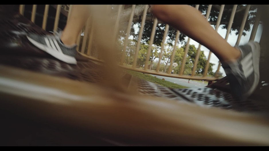 Young boy running across playground suspension bridge at the park ...