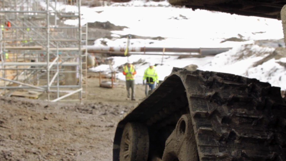 Over shoulder angle of snowmobile track with construction workers in ...