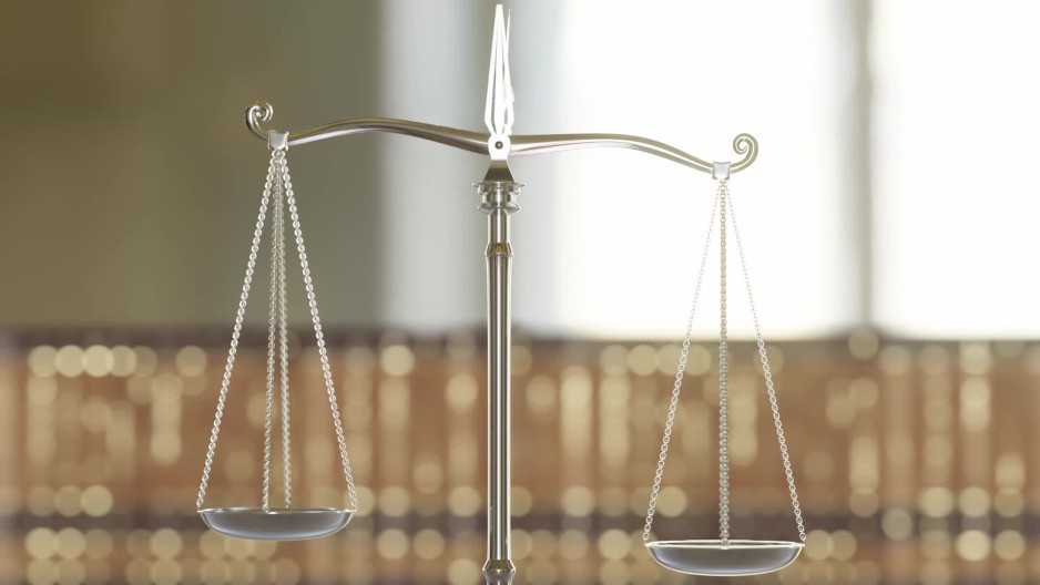 Legal scale silver tipping back and forth books in background wood ...