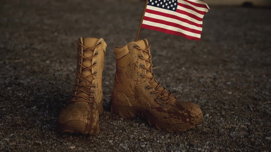 Muddy boots on ground with American flag inside it with war torn ...