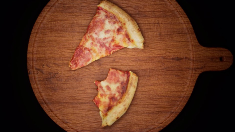 Realistic half eaten pizza slice rotating on black background | ClipStock