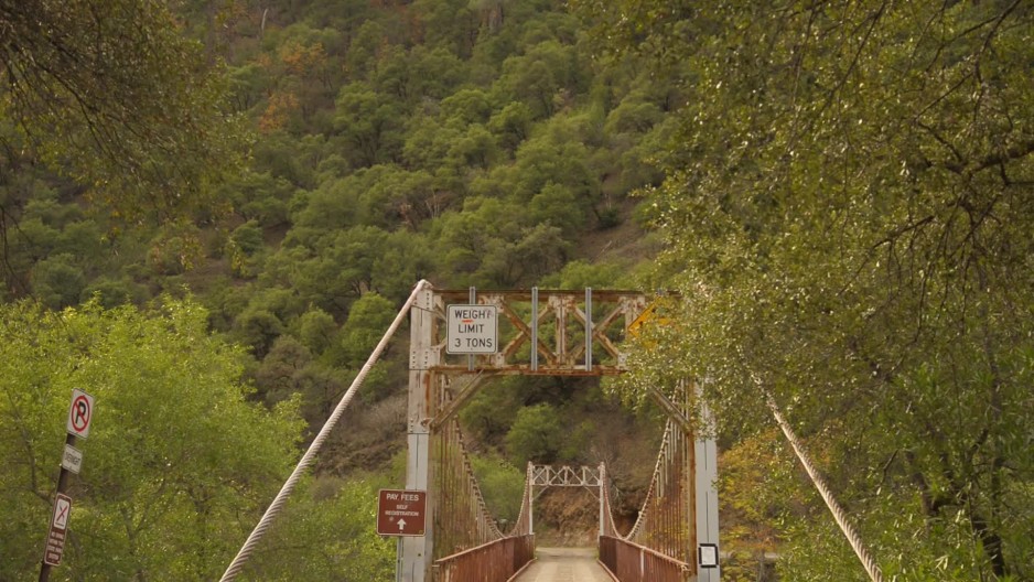 Tilt down of mountain into bridge with sign | ClipStock