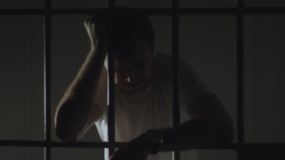 Young man crying locked up behind bars in jail - Slow Motion | ClipStock