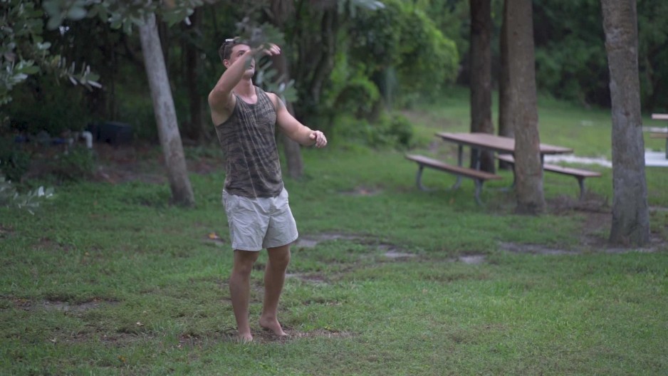 Athletic young man catching football with one hand during day at park ...