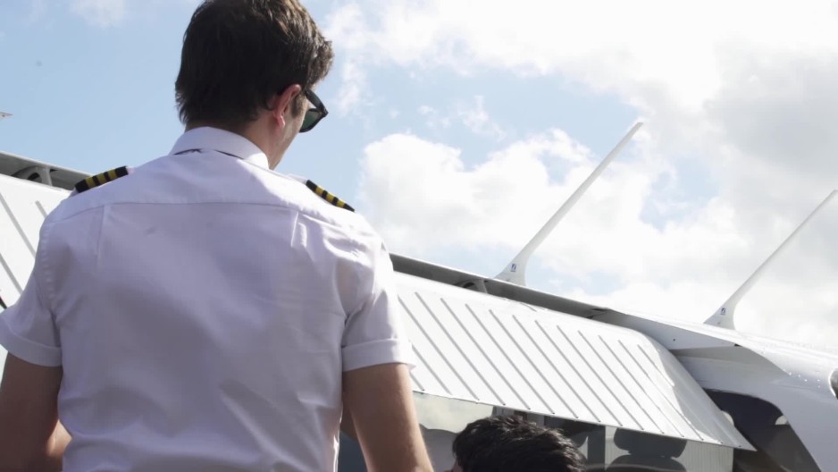 Young multiracial male pilots checking wing of prop plane | ClipStock