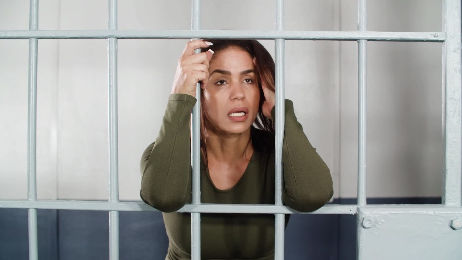 Woman behind bars freaking out | ClipStock