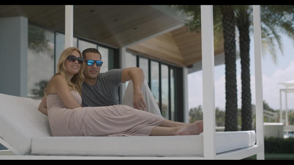 Beautiful Wife Coming To Lay Out With Husband On Poolside Patio Lounge Bed Of Upscale Modern